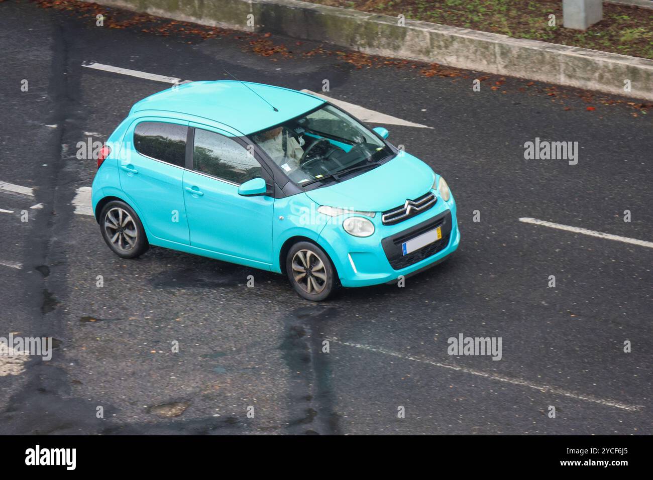 Modern turquoise car driving on the urban asphalt road Stock Photo - Alamy