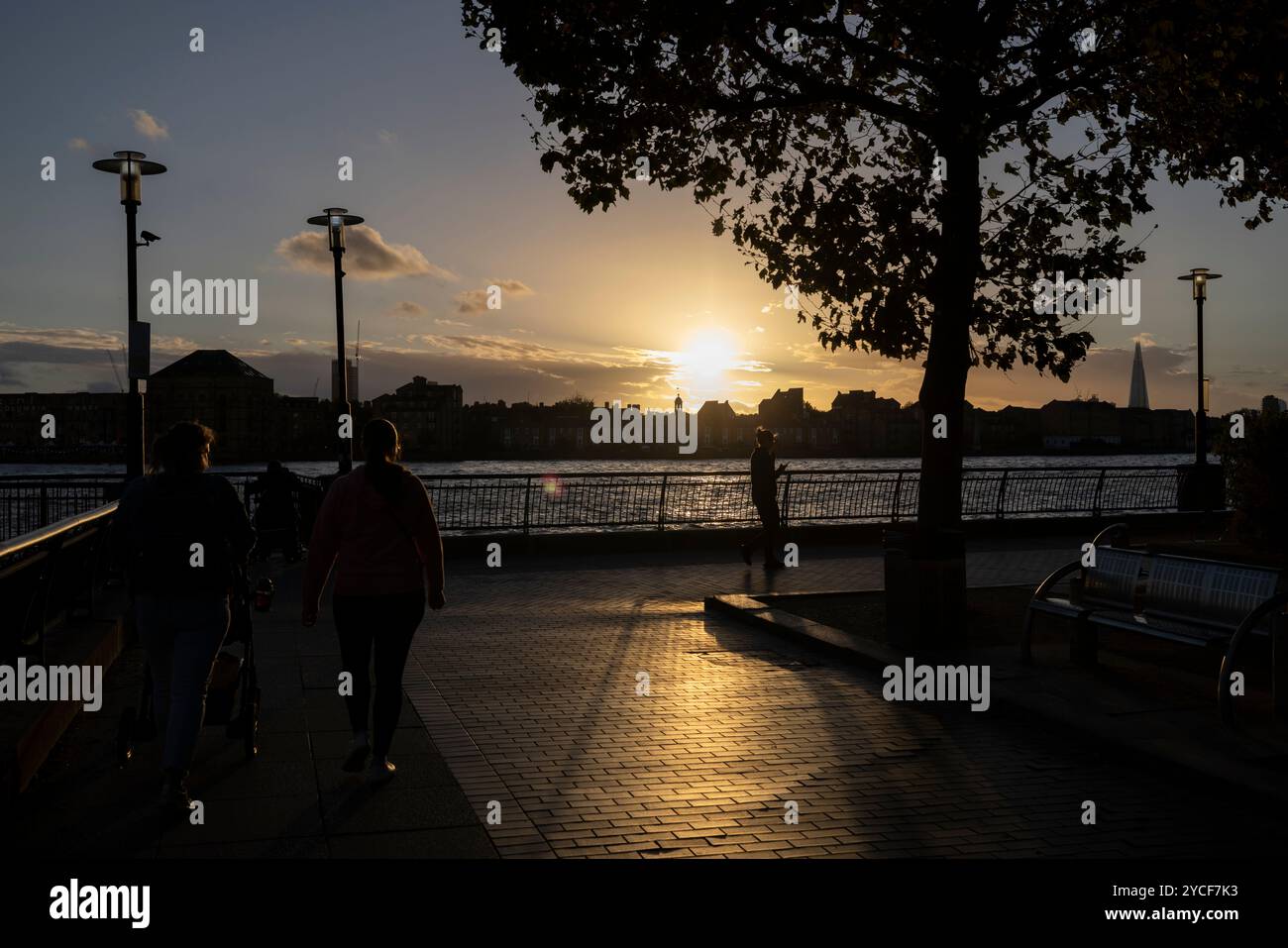 Families and friends evening walk during Autumn sunset along the River ...