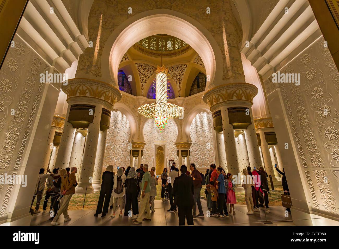 Visitors in the prayer hall, interior with chandelier, evening lighting ...