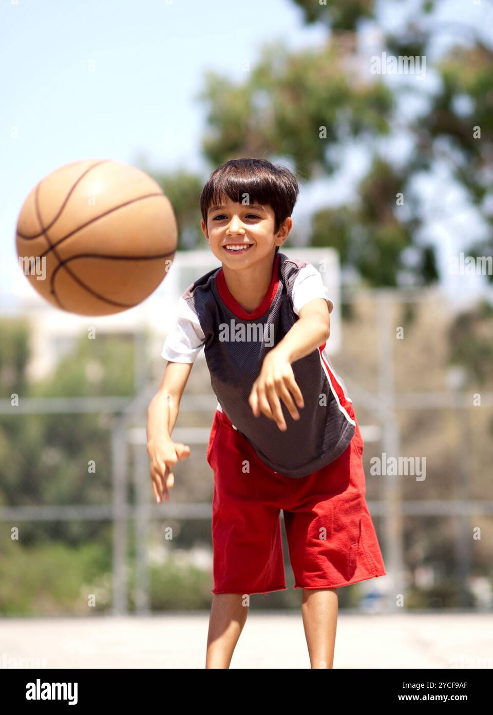 Young boy in action passing basketball Stock Photo - Alamy