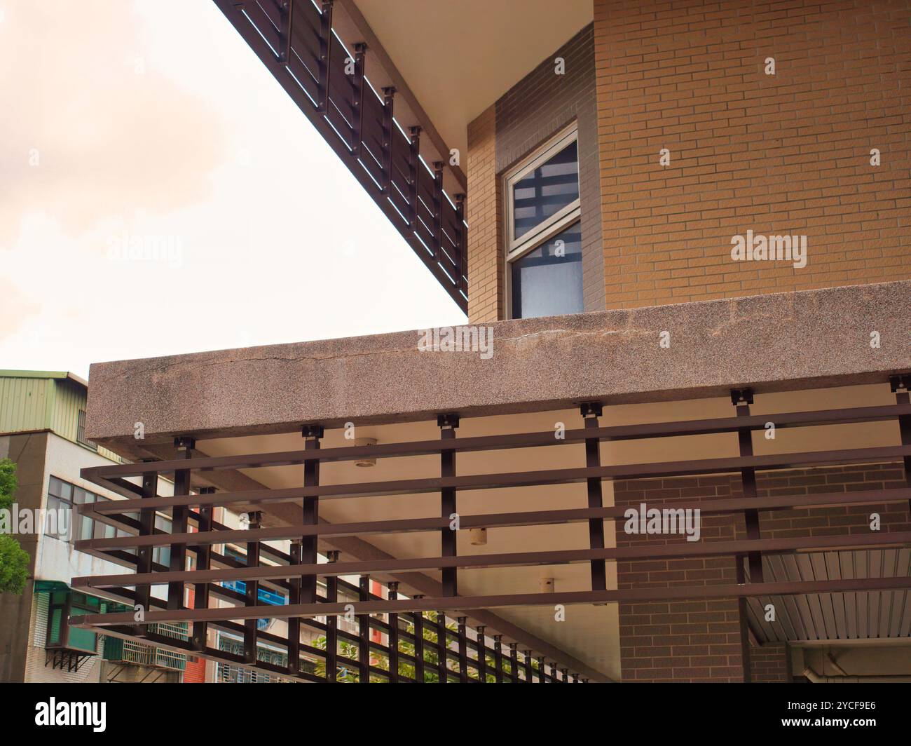 A modern building with brick walls features horizontal metal bars and ...