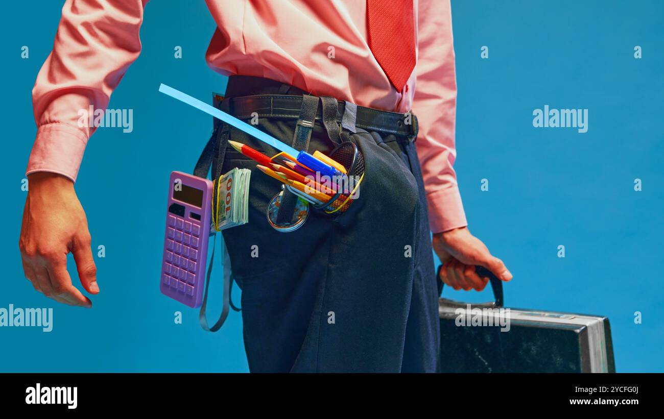 Back view of man's belt filled with office tools, including pens ...