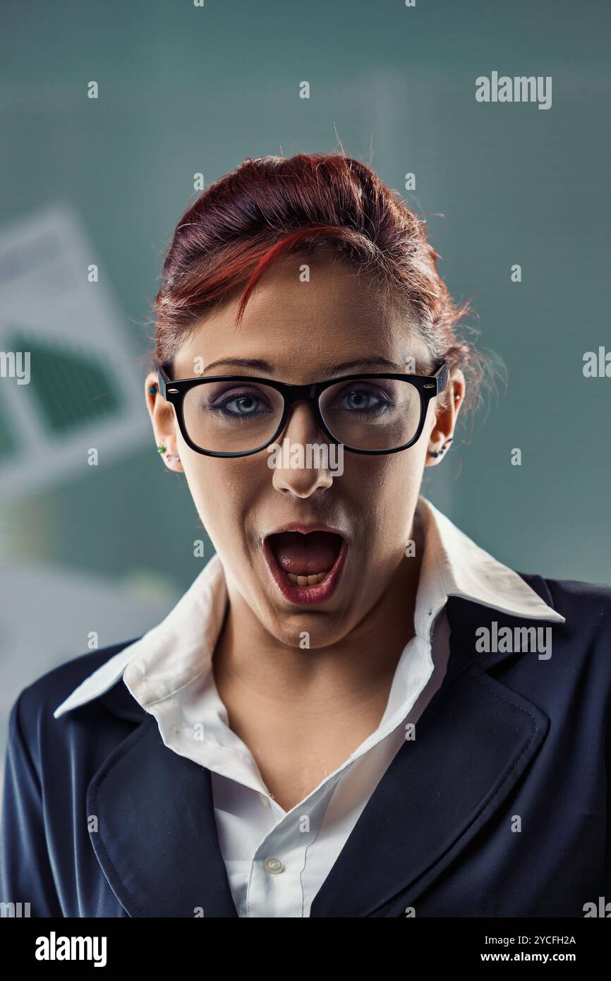 Shocked businesswoman in glasses, mouth wide open in disbelief, eyes ...