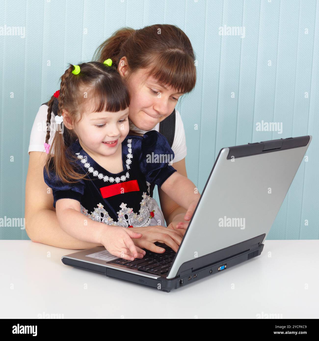 Mom teaches daughter to use laptop Stock Photo - Alamy