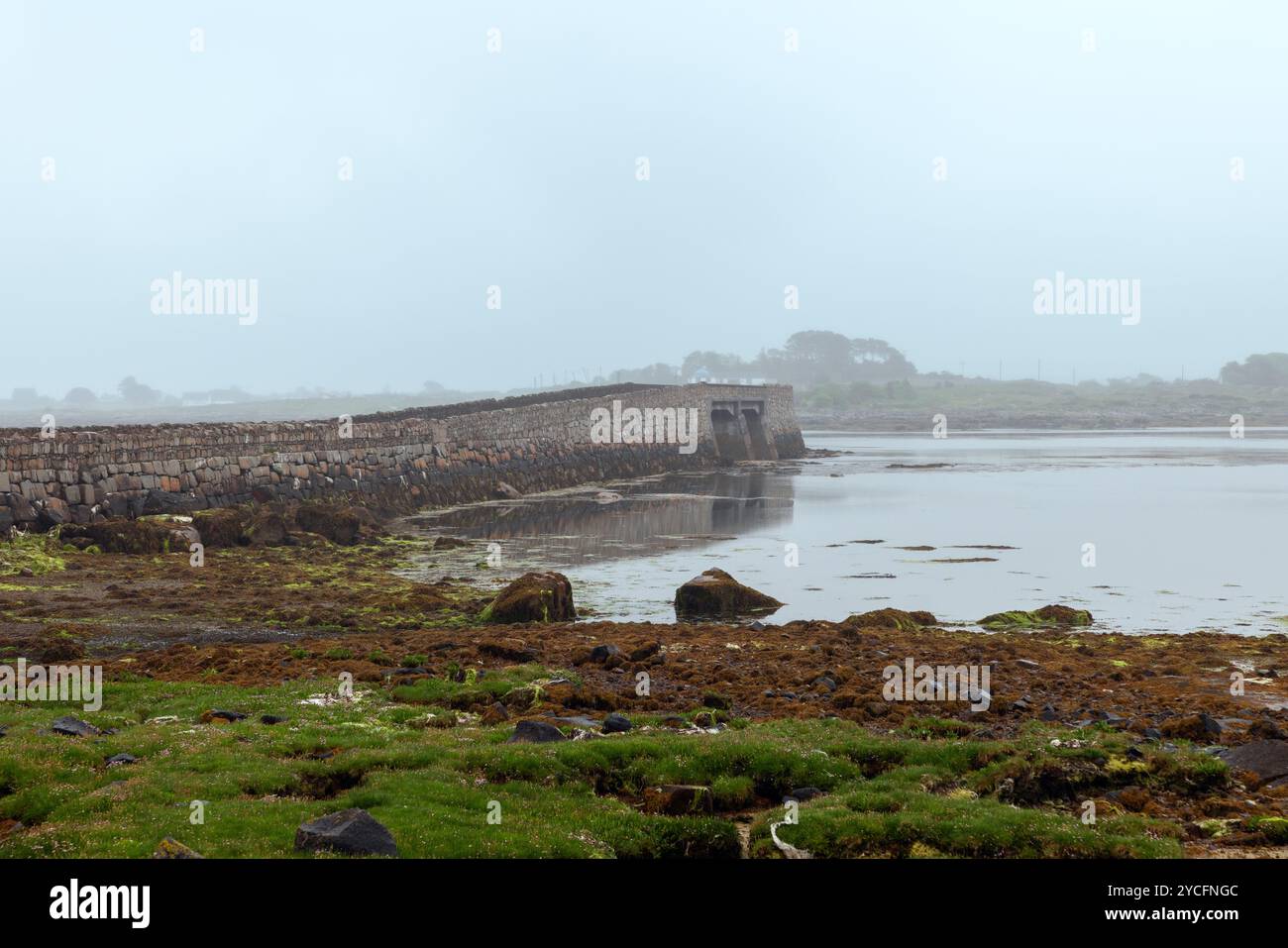 Overcast day in Connemara, Ireland, showcasing a historic stone bridge ...