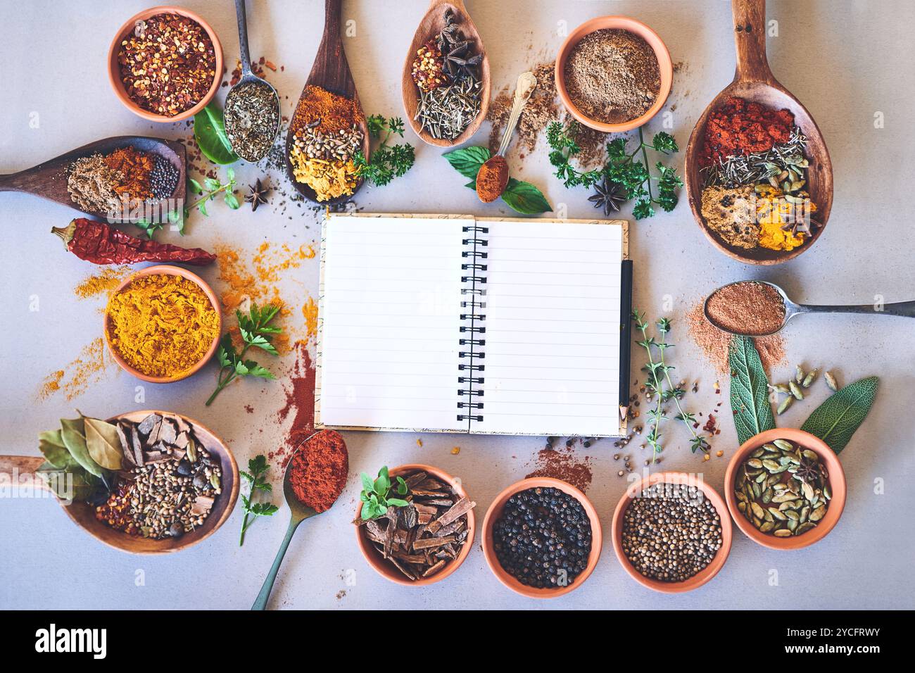 Spices, ingredients and variety of herbs with cookbook on studio ...