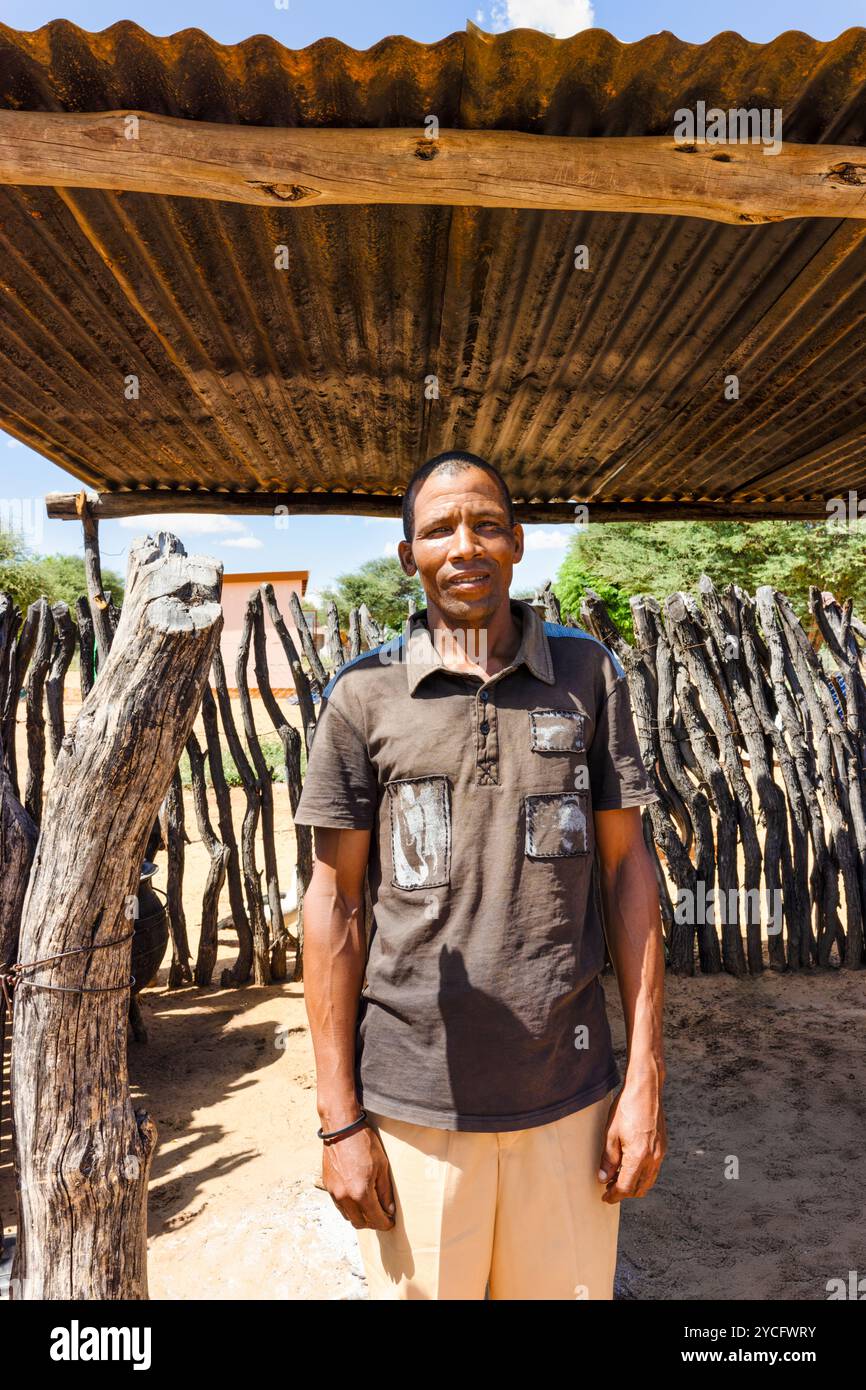 village happy african man in the outdoors kitchen, wood fence and house ...