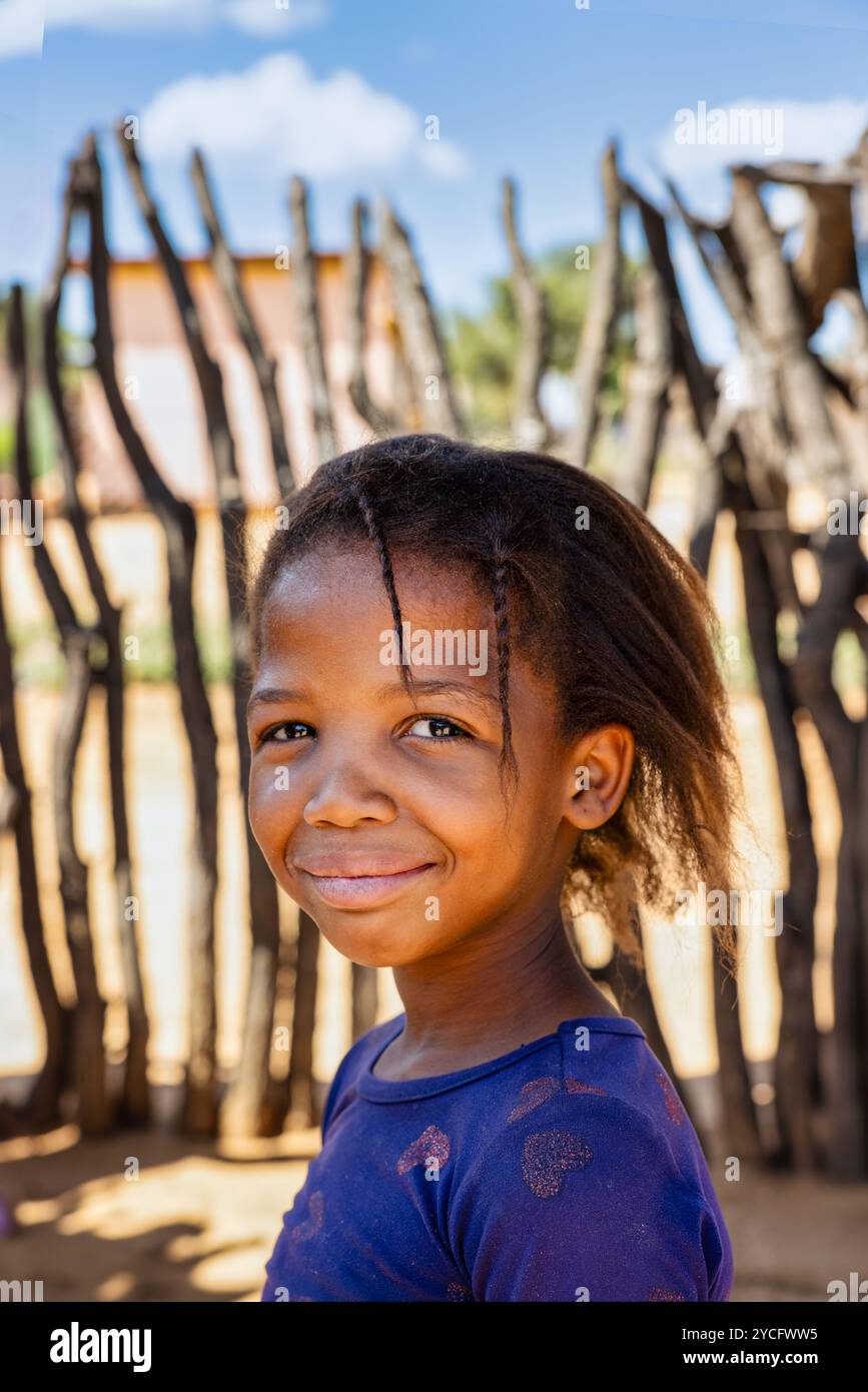 village single African child girl standing in the yard in front of the ...