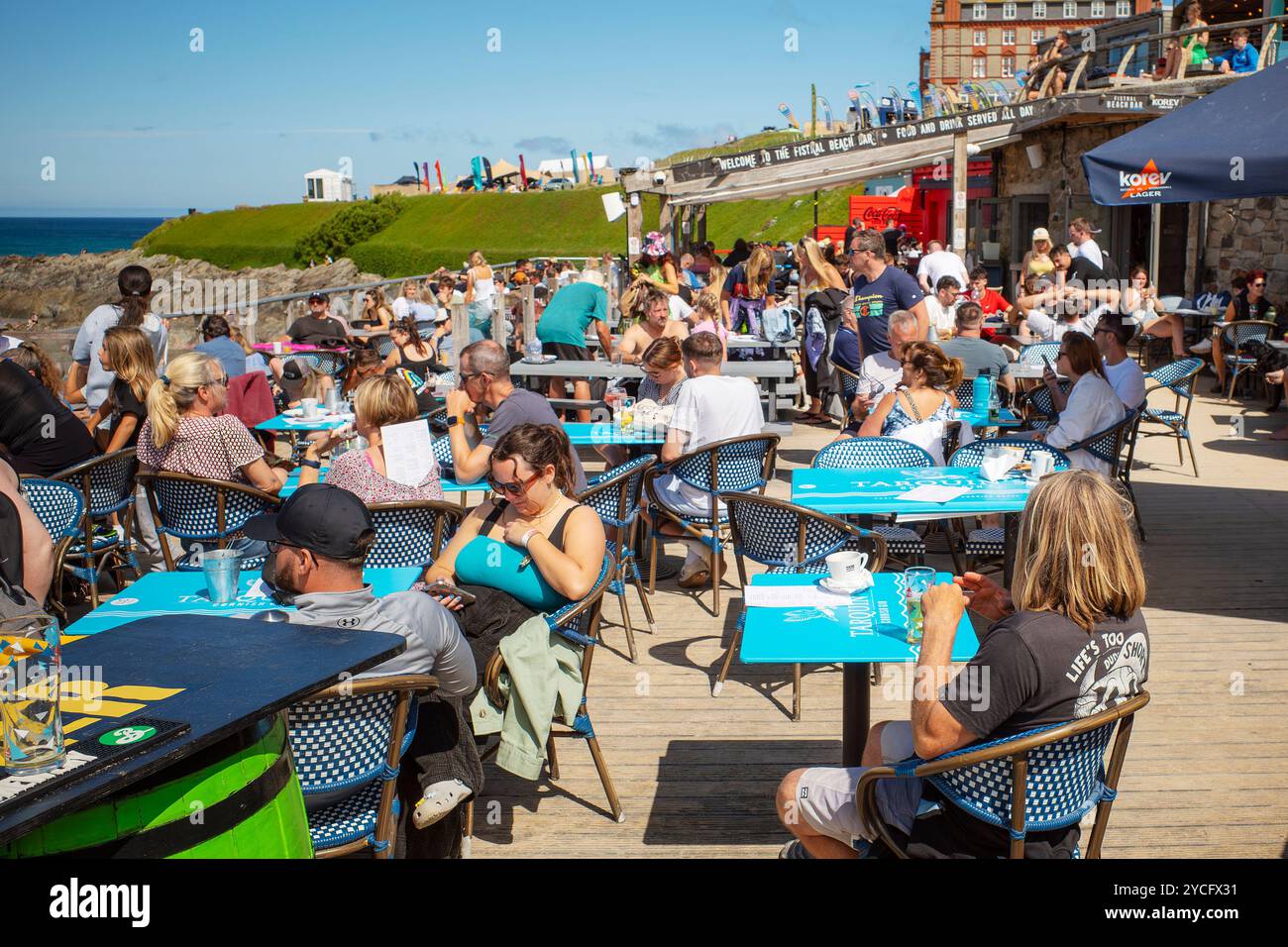 Holidaymakers enjoying the summer sunshine sitting on the outdoor ...