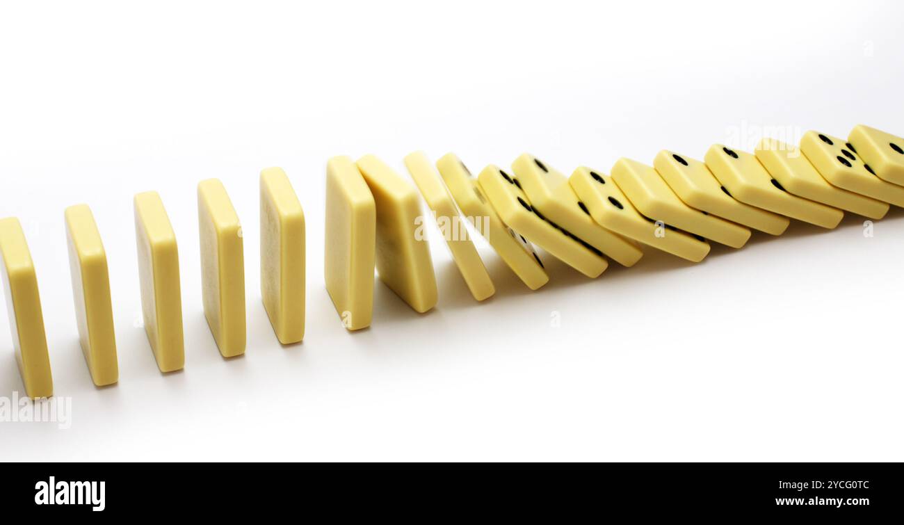 Falling column of a dominoe on a white background Stock Photo - Alamy