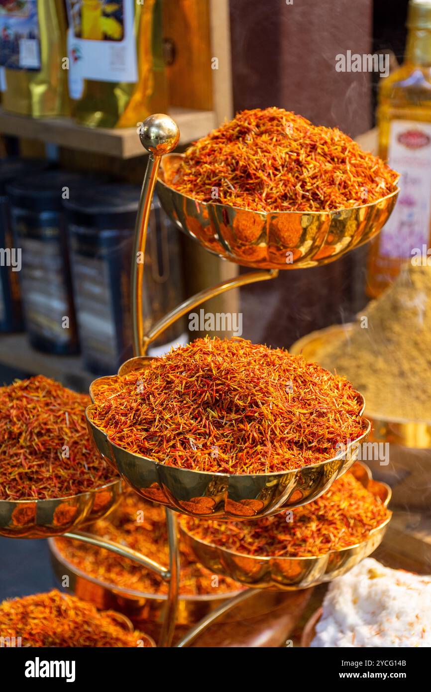 Golden tiered bowls display bright red saffron threads at a market in ...