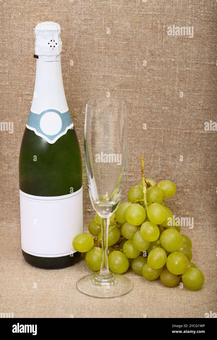 Still-life from bottle of sparkling wine, empty glass and grapes Stock ...