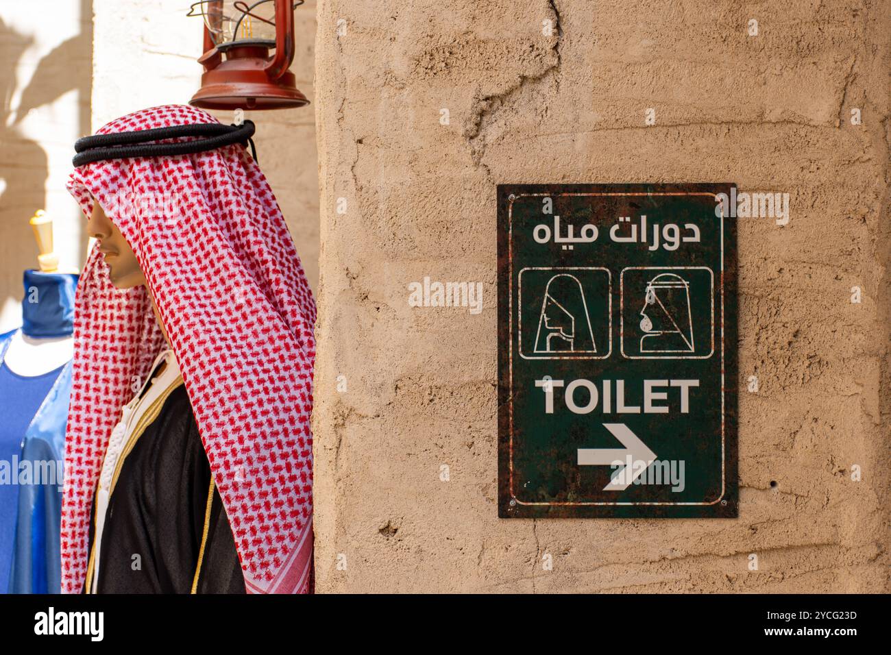 Green toilet sign with Arabic and English text with male and female ...