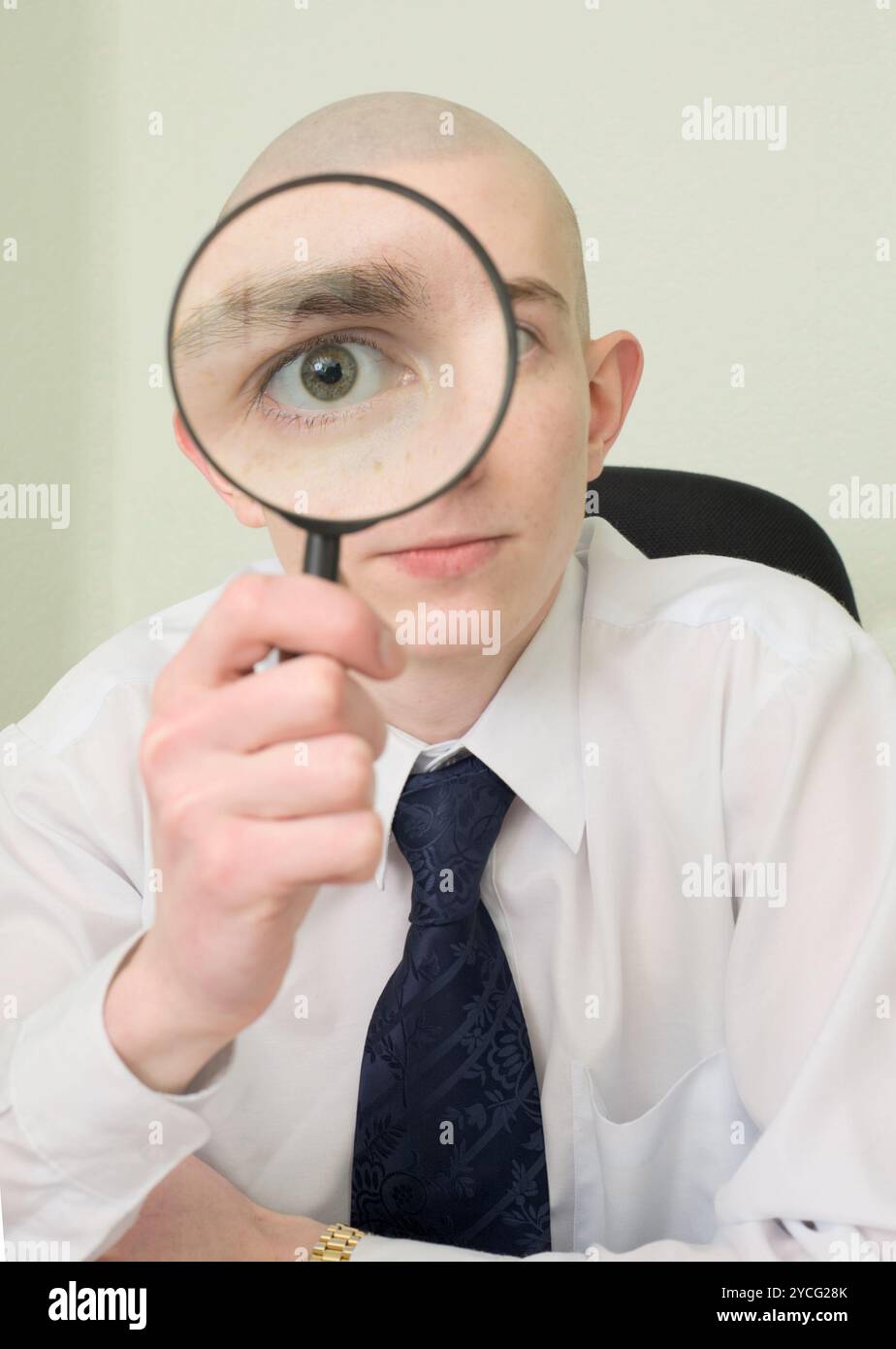 Guy looks through the big magnifier Stock Photo - Alamy