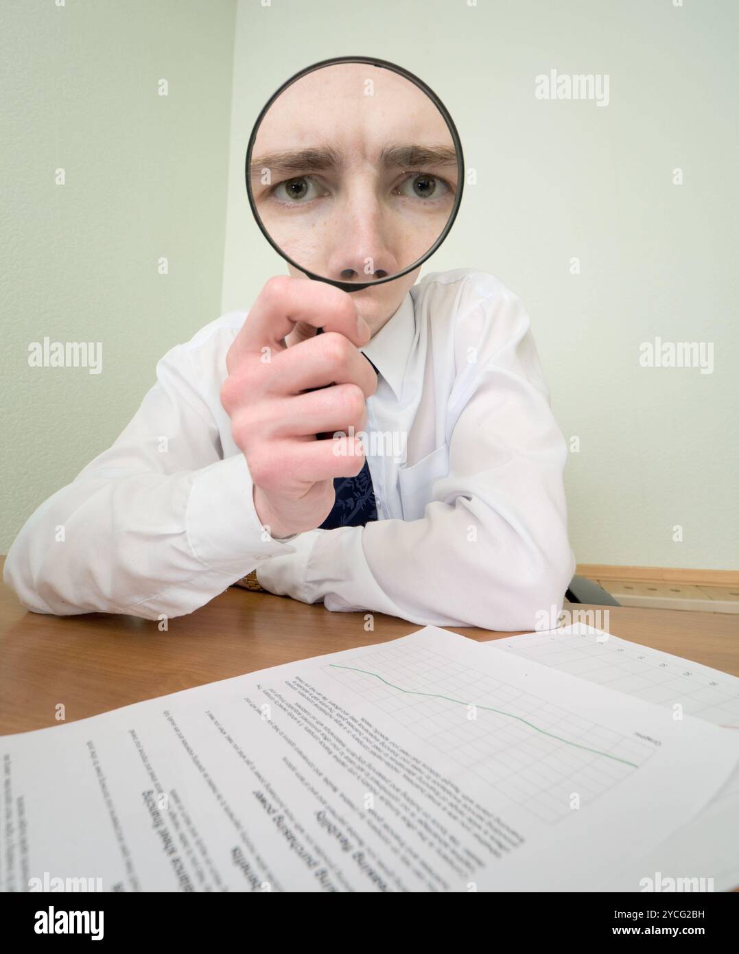 Guy looks through the magnifier Stock Photo - Alamy