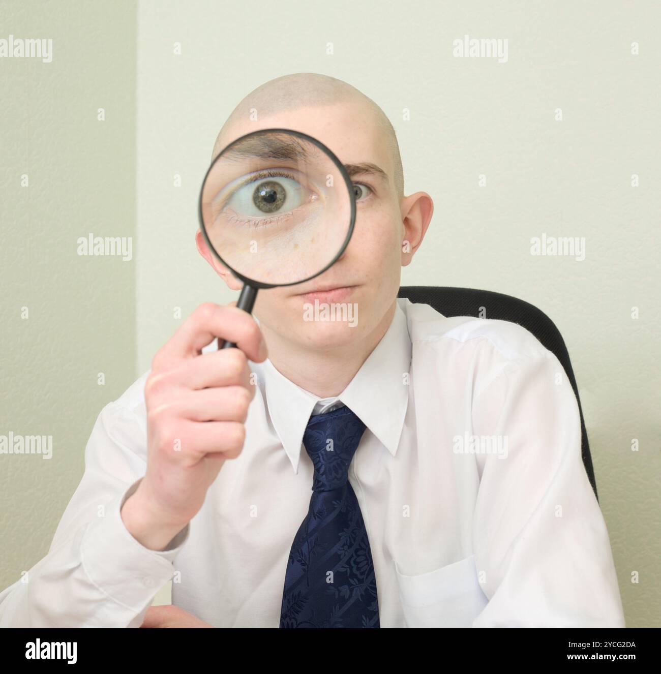 Guy looks through the big magnifier Stock Photo - Alamy