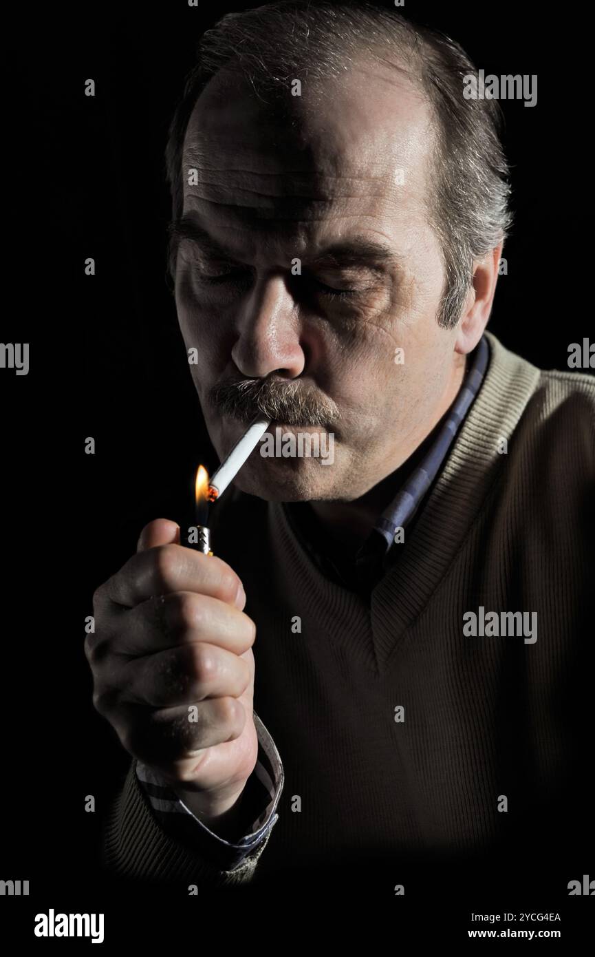 Portrait of a man lighting cigarette Stock Photo - Alamy