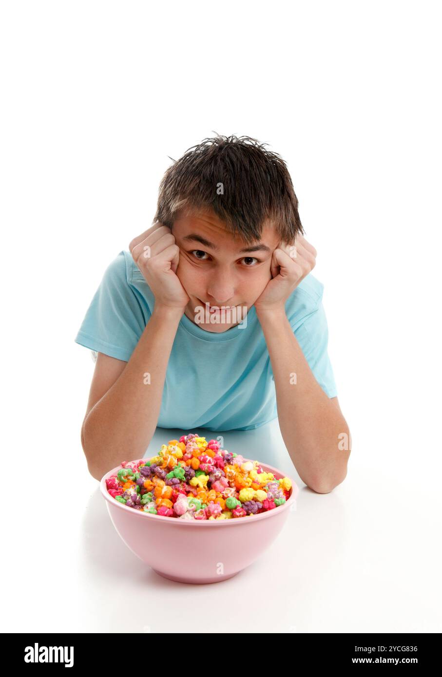 Boy relaxes with bowl of snack food Stock Photo - Alamy