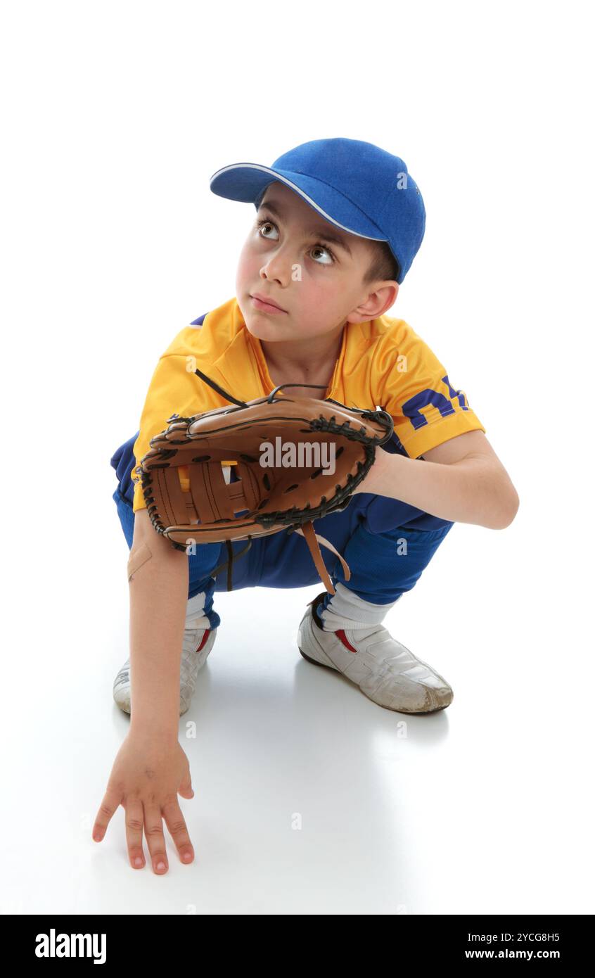 A little boy baseball player crouching down with a mitt. Space for copy ...