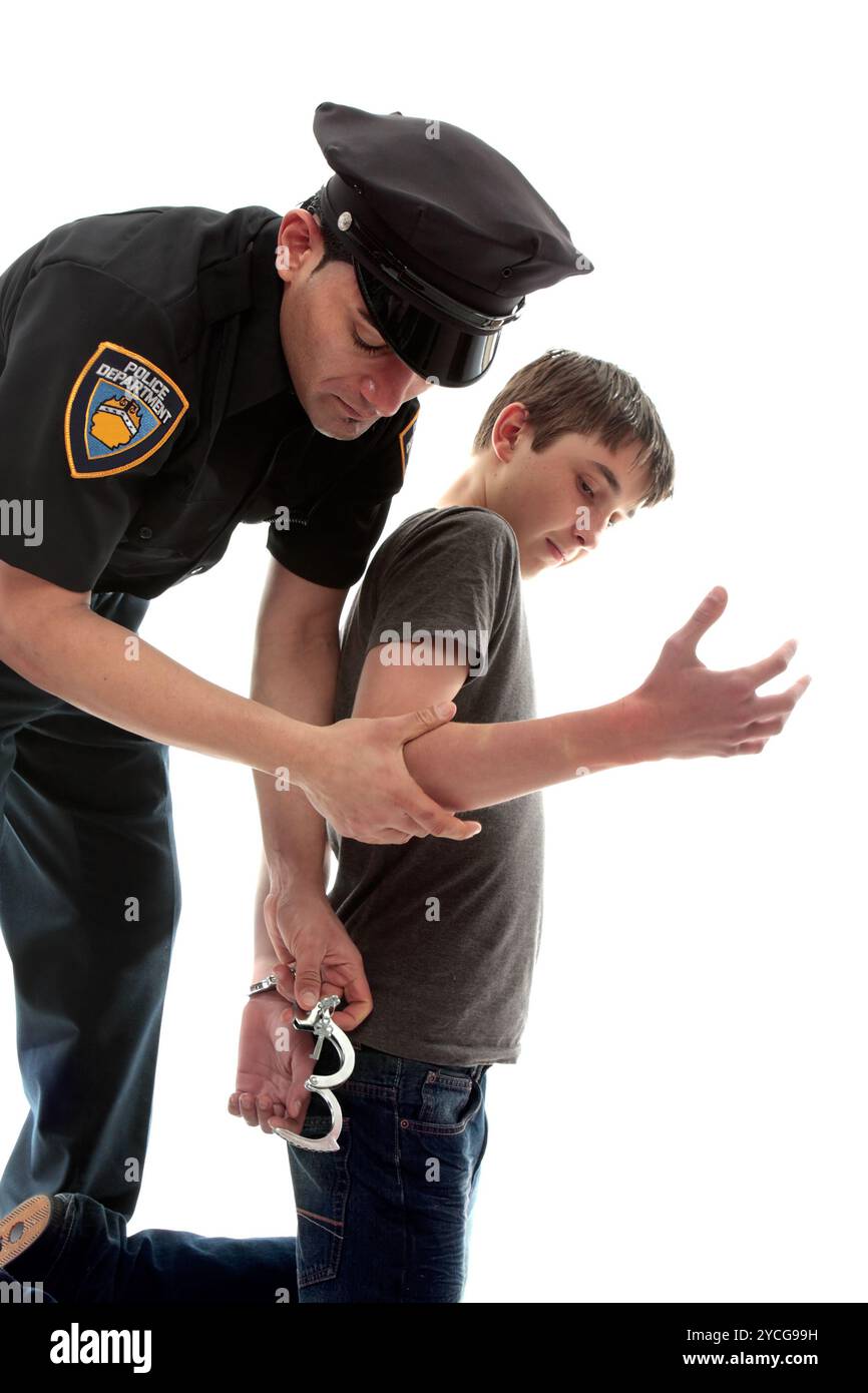 A uniformed policeman arrests and handcuffs a young teen criminal Stock ... A uniformed policeman arrests and handcuffs a young teen criminal Stock ...