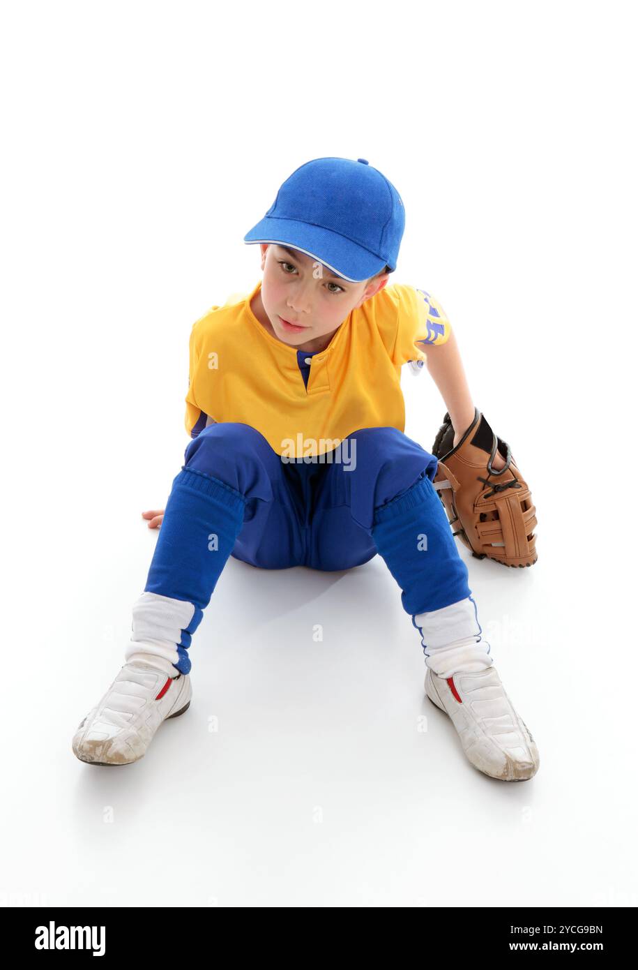 A young boy dressed in baseball tball sports clothing and wearing a ...