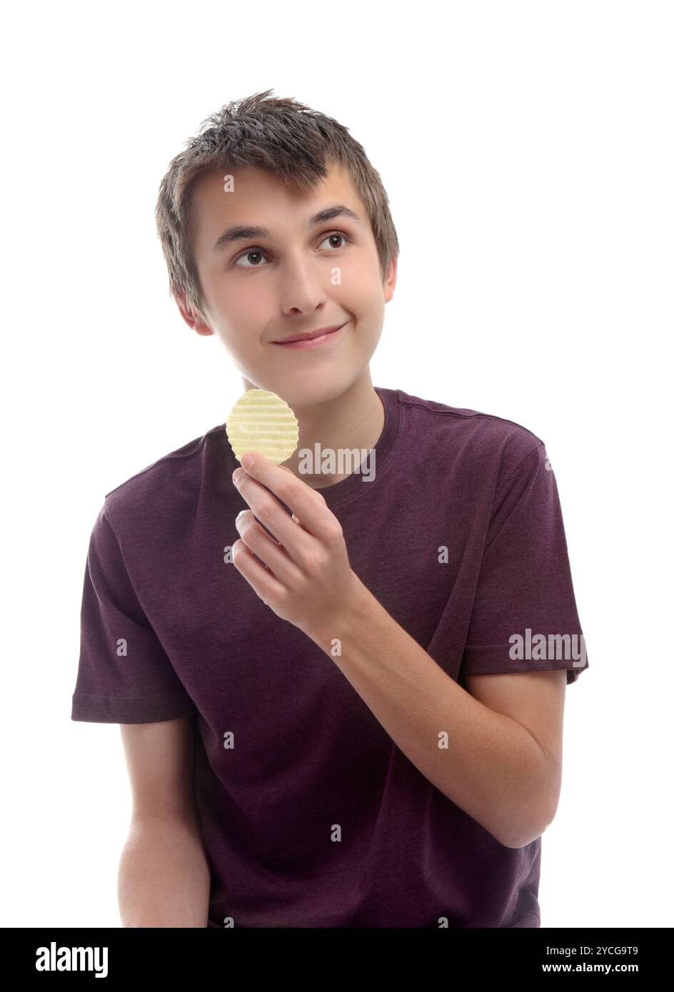 A boy holding a single potato crisp chip and looking sideways at your ...