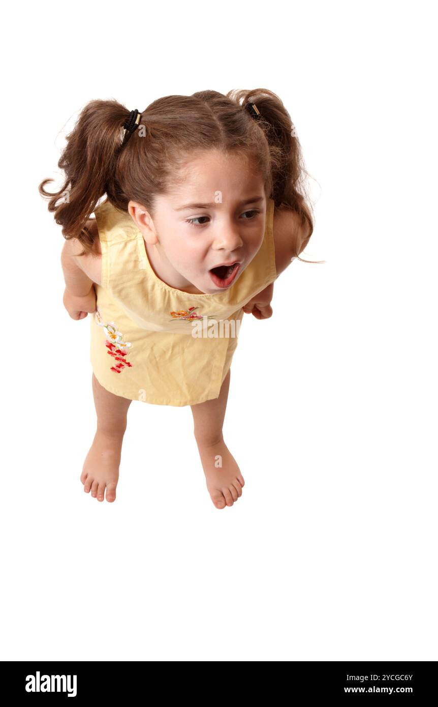 A young little girl with fists clenched screams or throws a tantrum ...