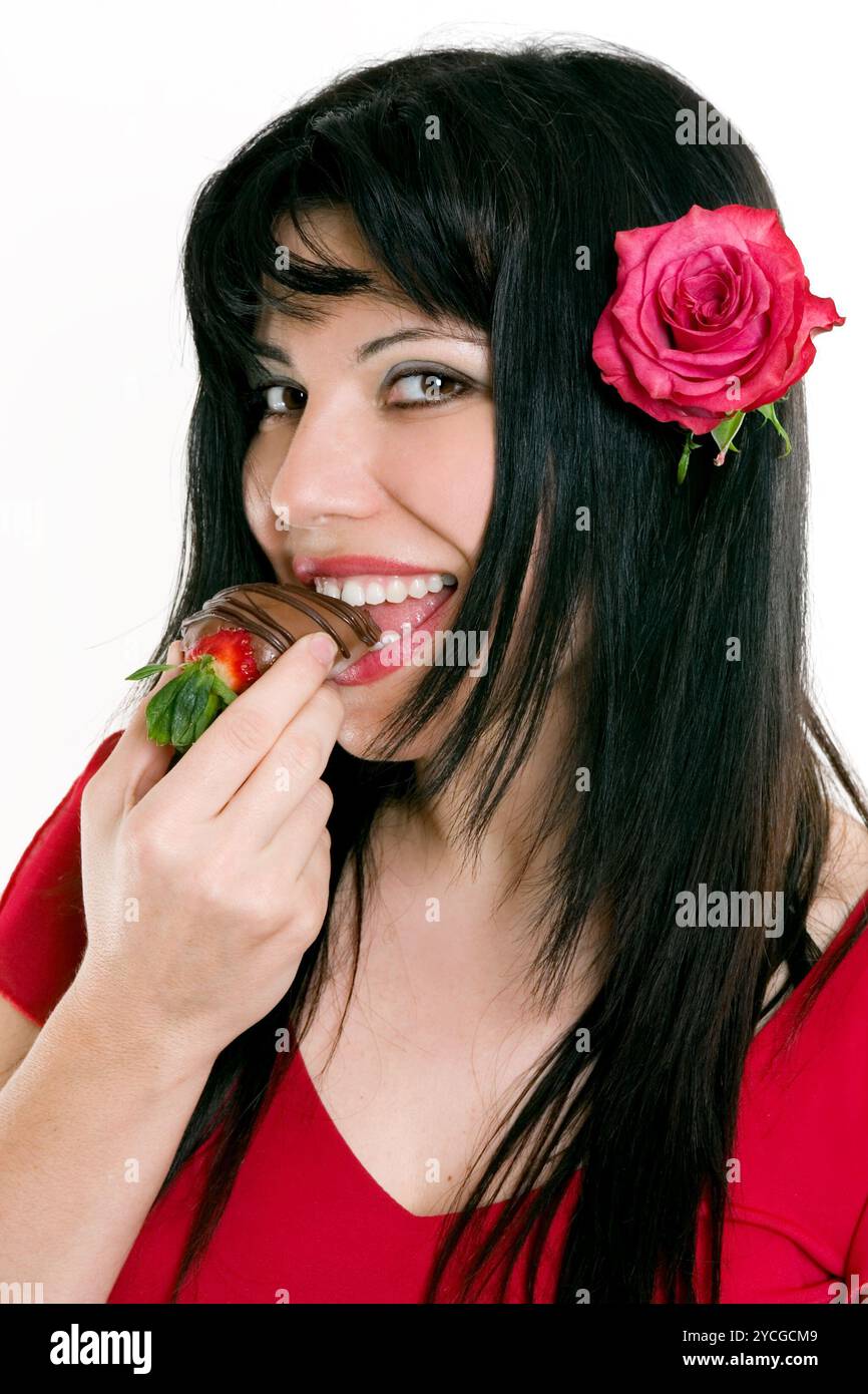 Beautiful female eating luscious strawberries, dipped in a coating of ...