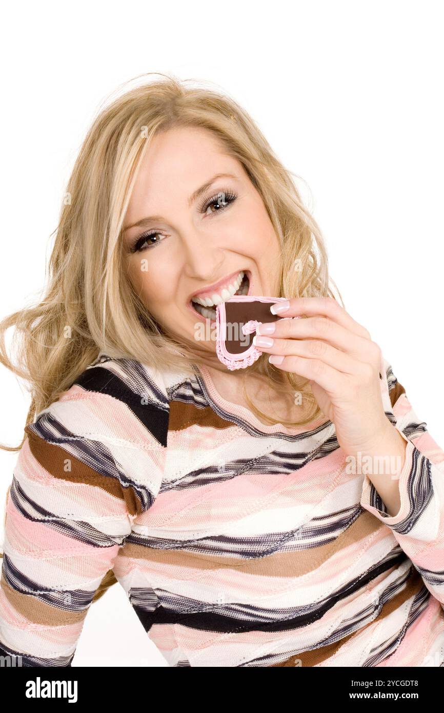 Female biting chocolate heart Stock Photo - Alamy