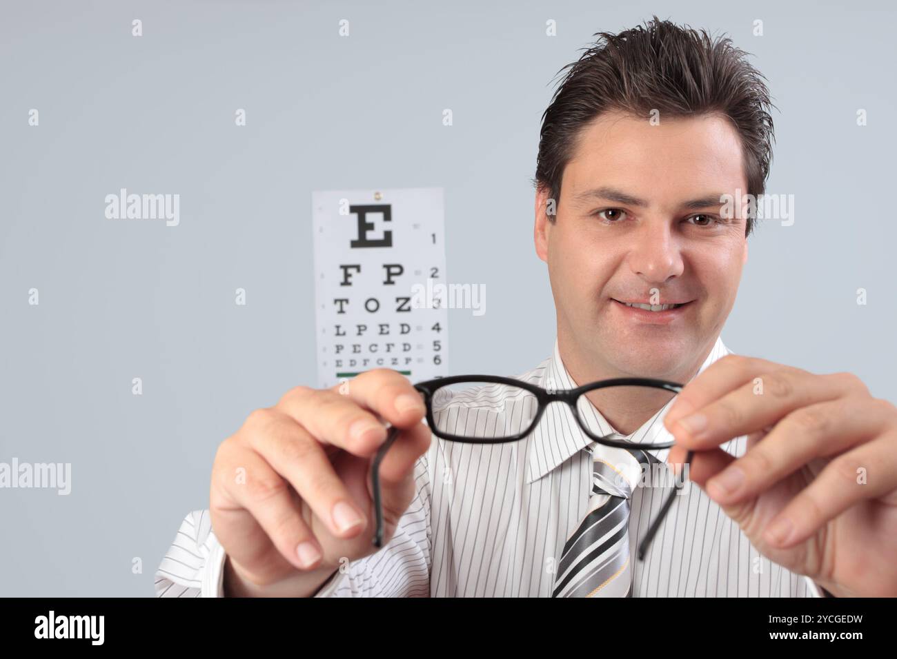 Optometrist holding eye frames Stock Photo - Alamy