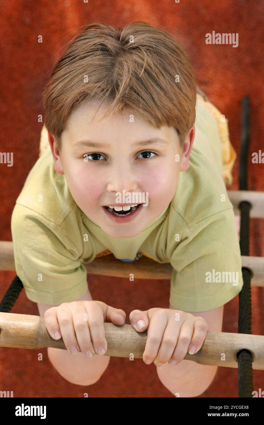 Climbing a rope ladder at playground Stock Photo - Alamy
