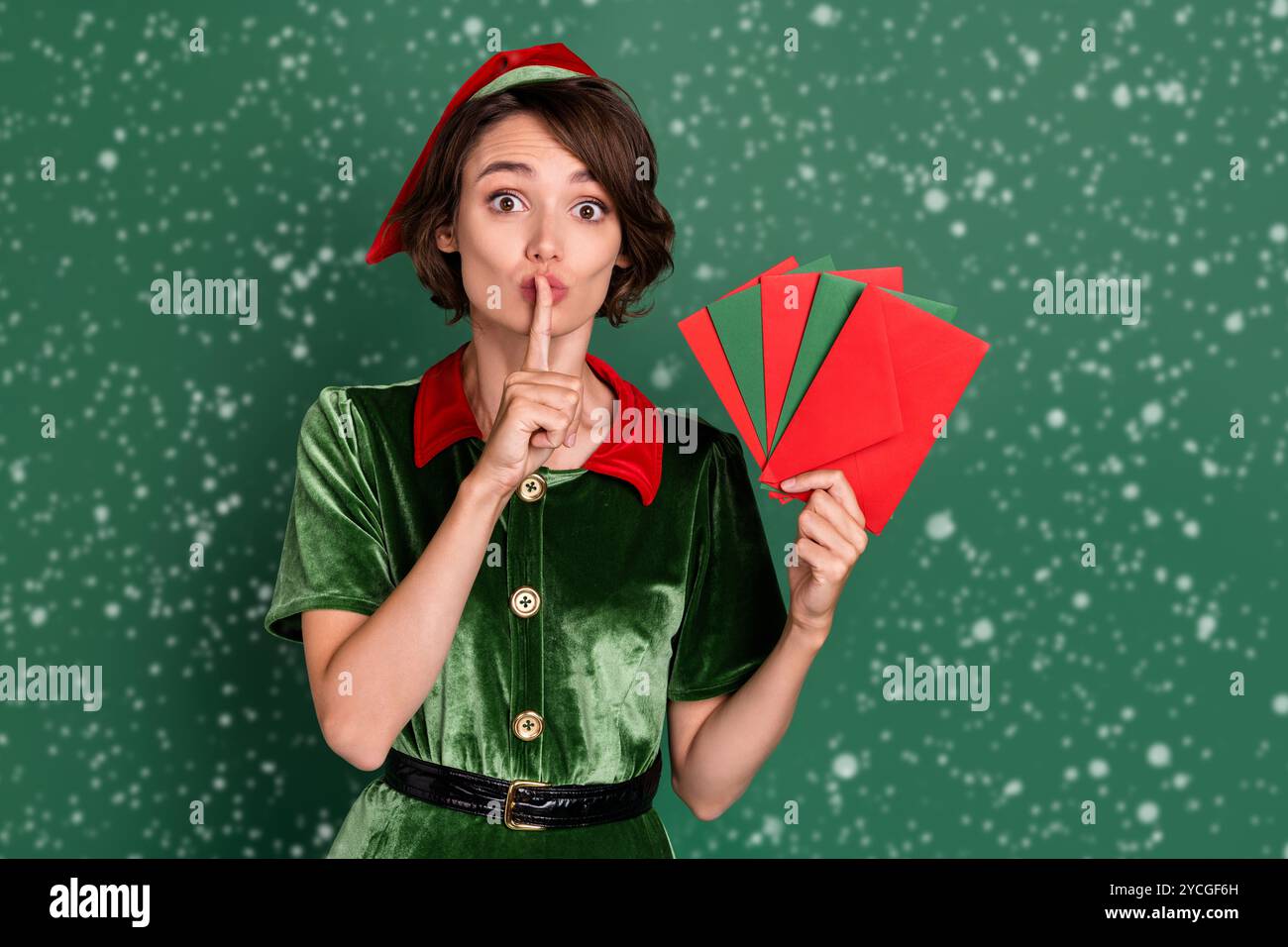 Portrait of attractive mysterious girl holding letters showing shh sign ...