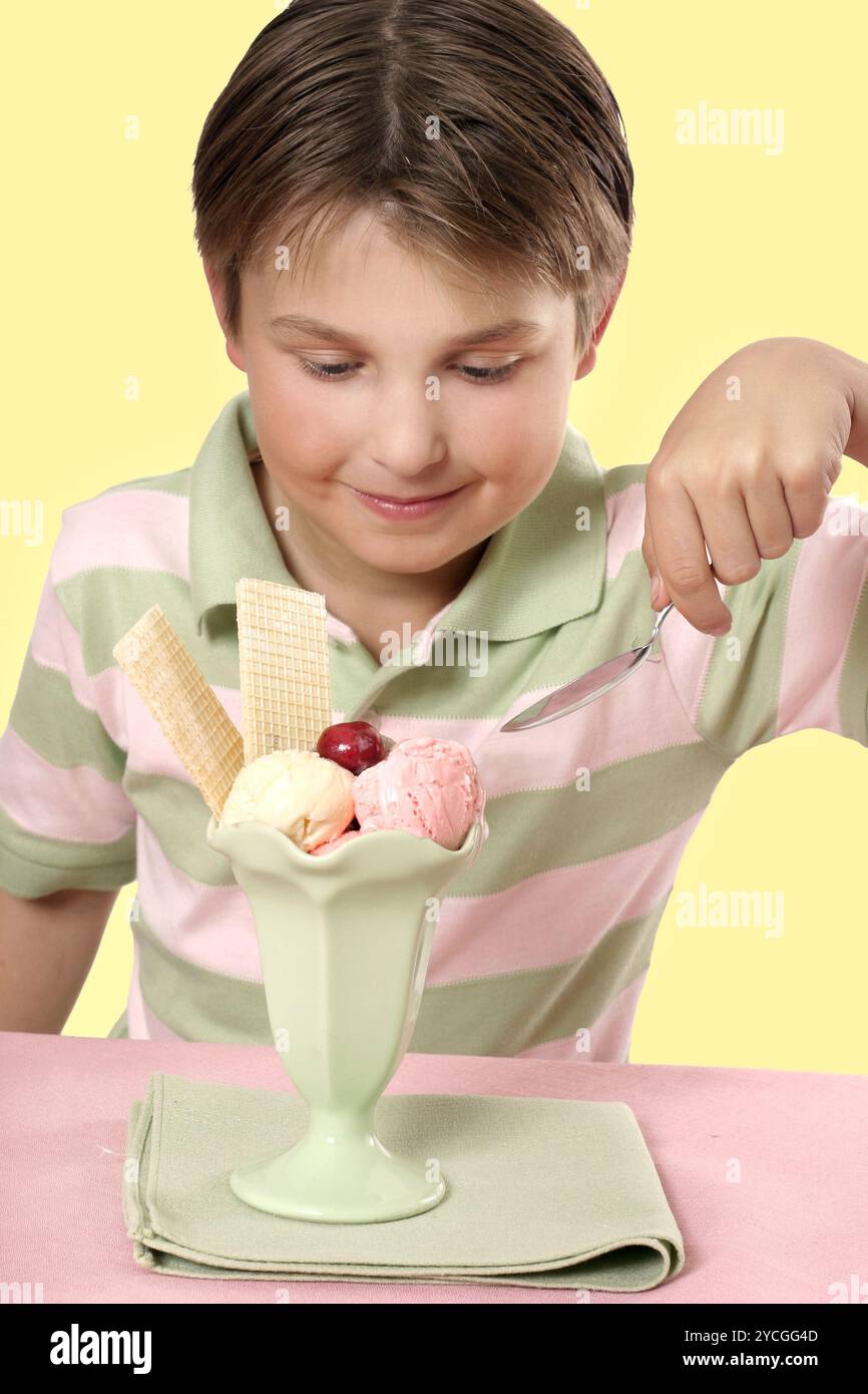 Child tucking into an ice cream undae Stock Photo - Alamy
