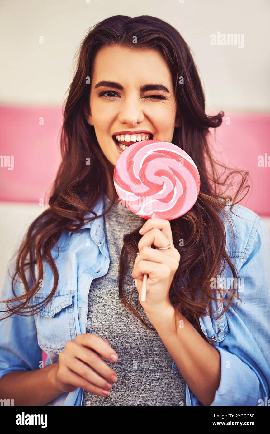 Outdoor, woman and wink with candy for fashion with street style ...