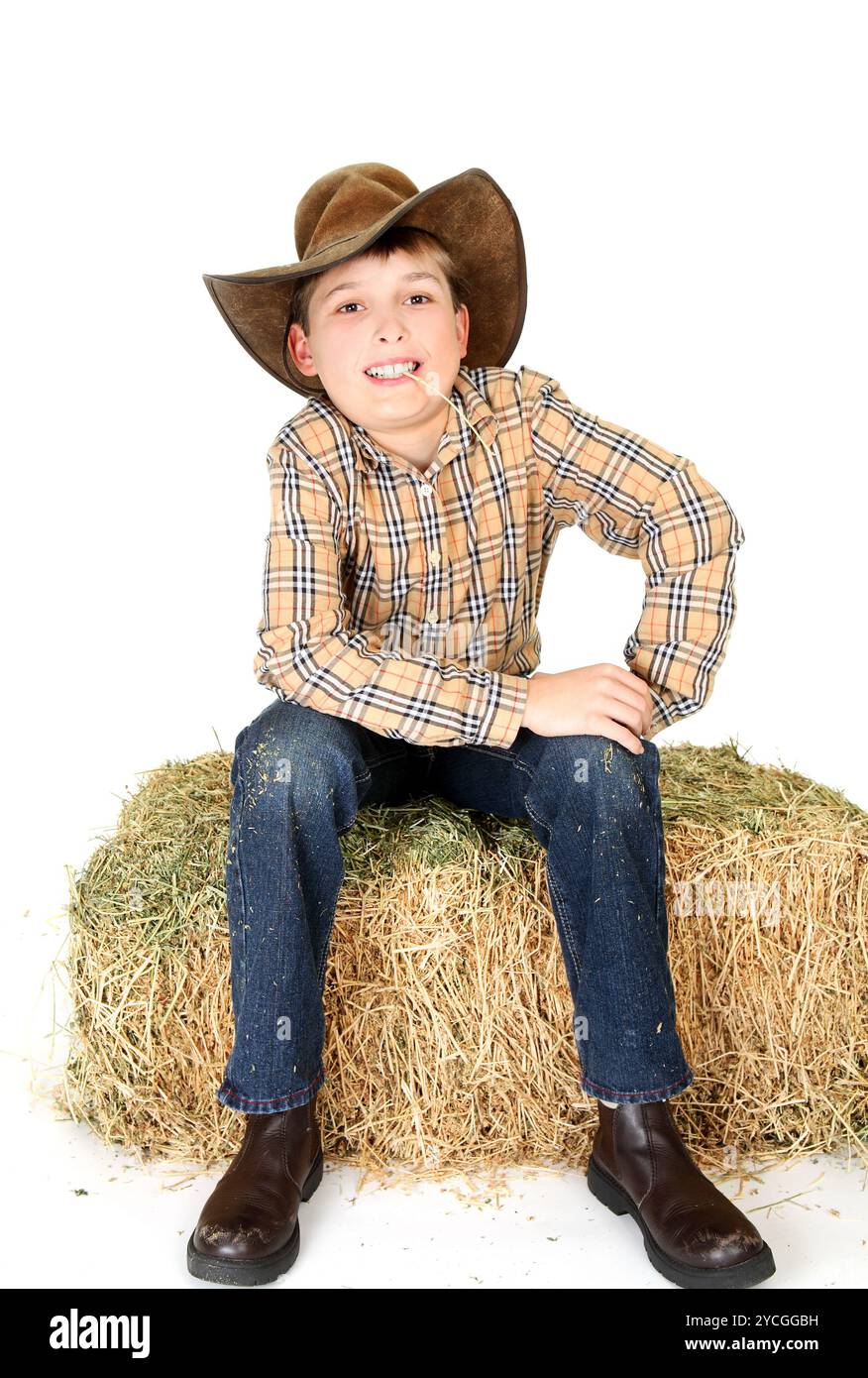 Farm boy chewing on a piece of straw Stock Photo - Alamy