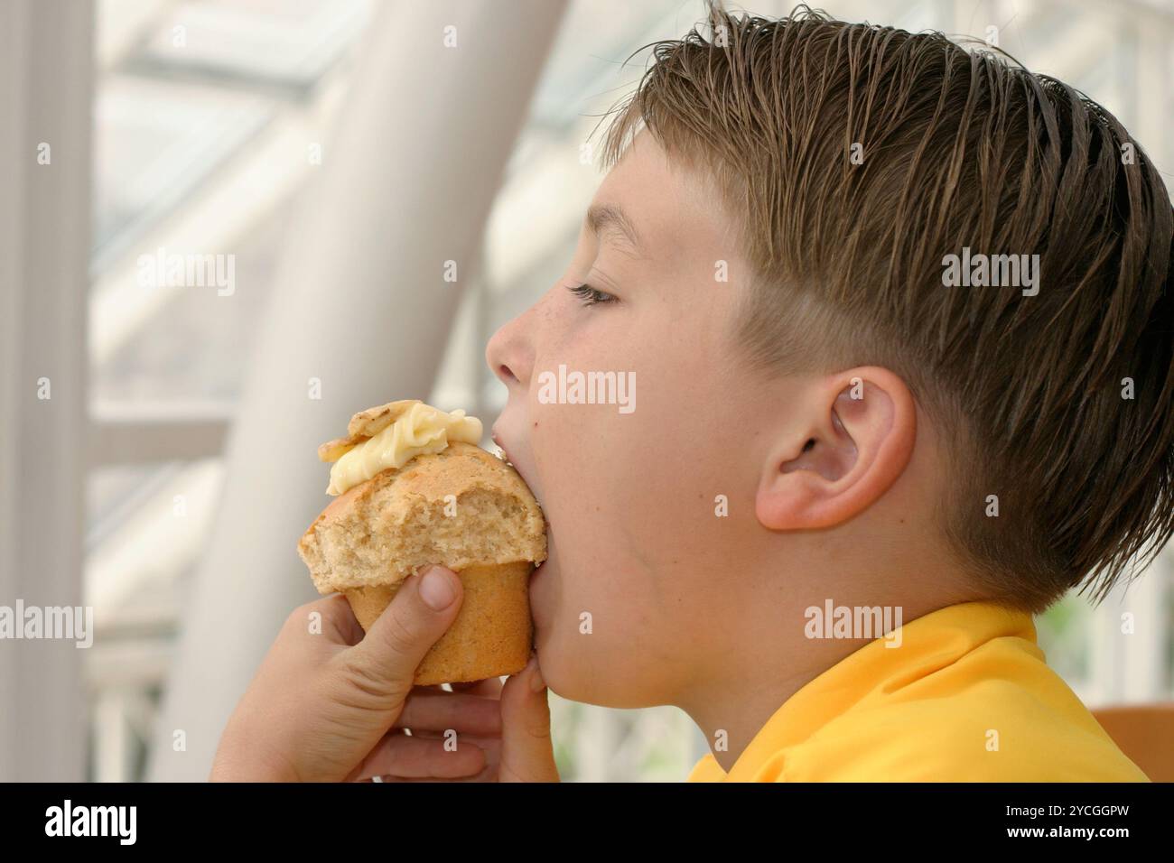 Boy eating a banana muffin Stock Photo - Alamy