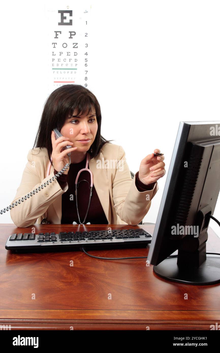 Doctor using computer and telephone Stock Photo - Alamy