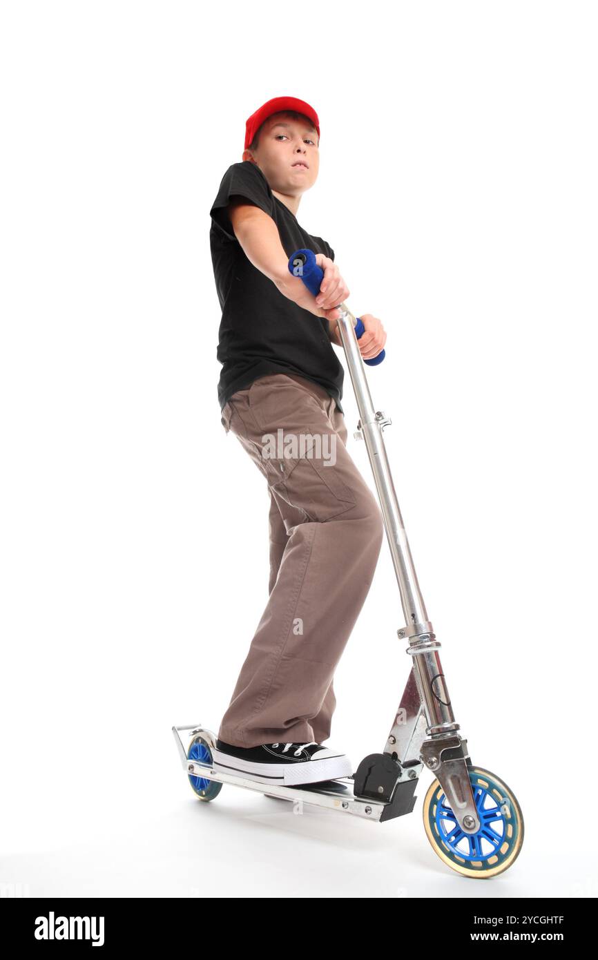 A boy stands by a scooter - taken from low ground level viewpoint ...