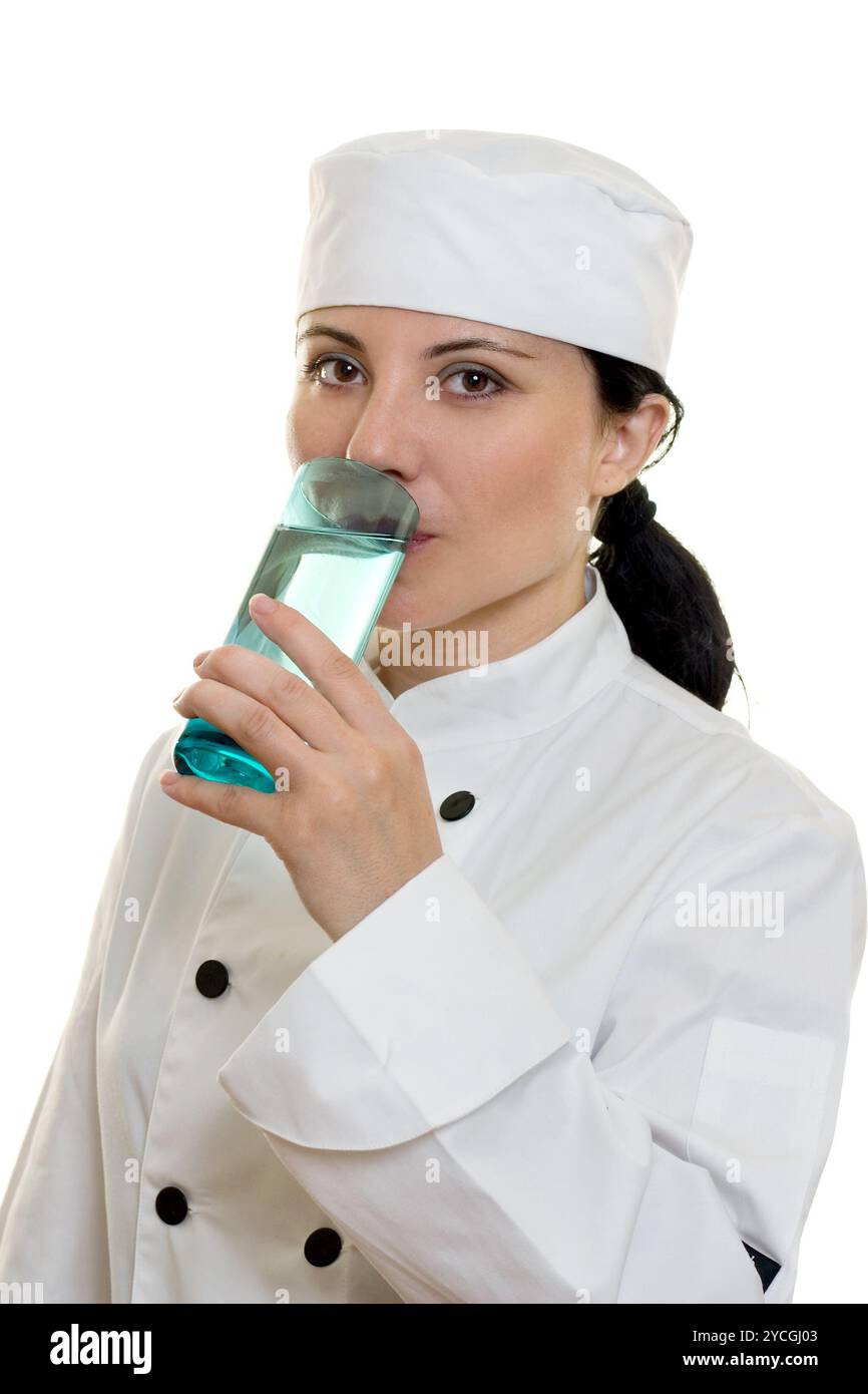 Female chef or cook drinking a glass of fresh spring water. White ...