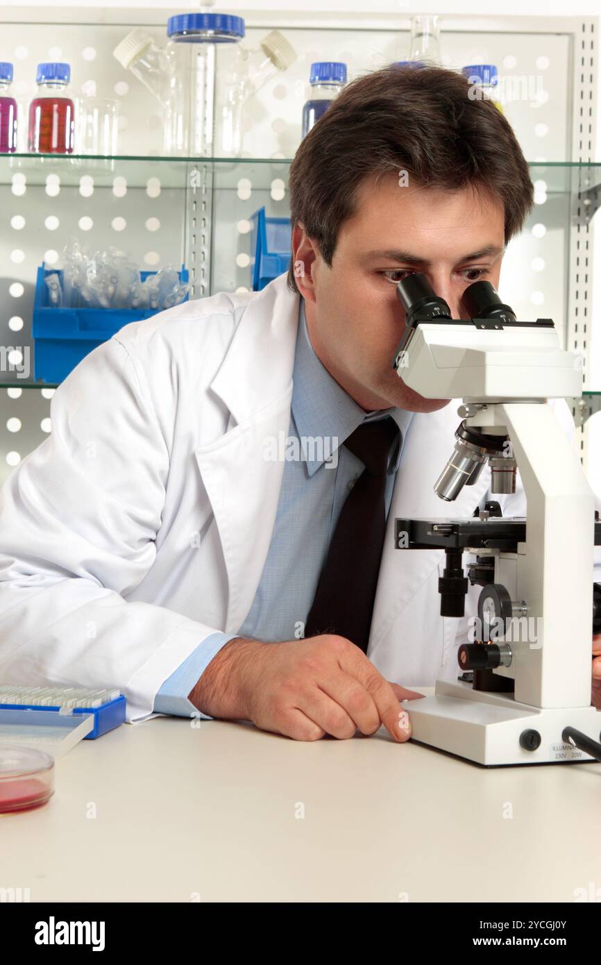 Scientist looking through microscope Stock Photo - Alamy