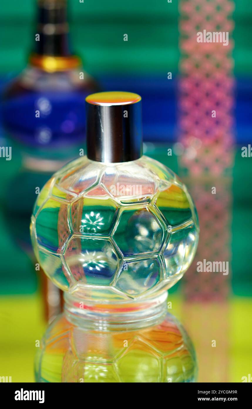 Glass bottles with perfumery. On a color background with reflection ...
