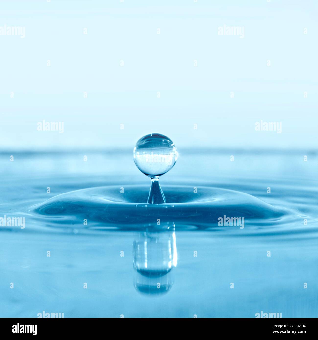 Falling drop of blue water Stock Photo - Alamy