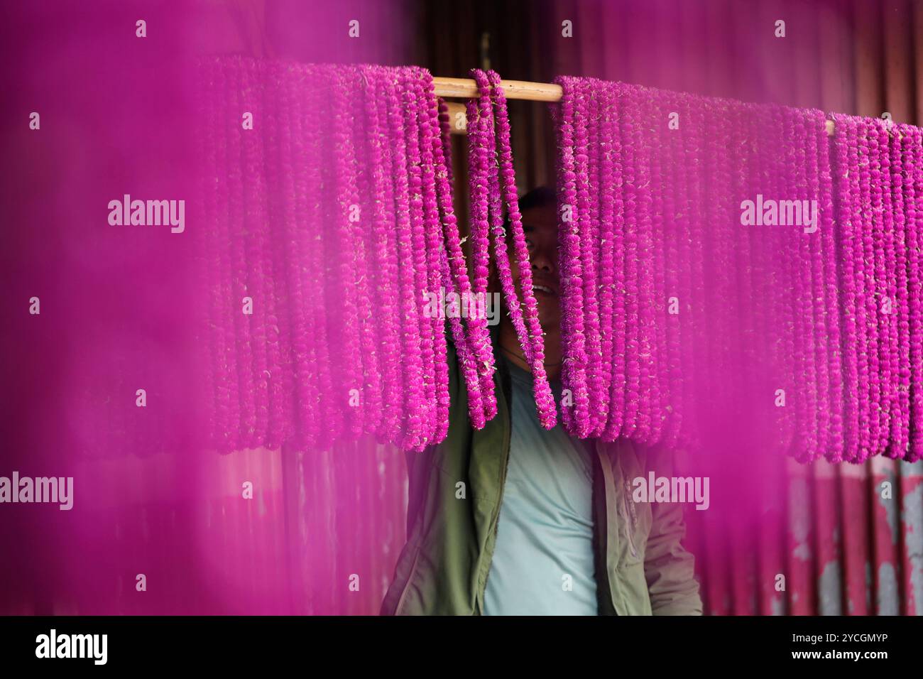 Kathmandu, Nepal. 23rd Oct, 2024. A man hangs garlands made of ...