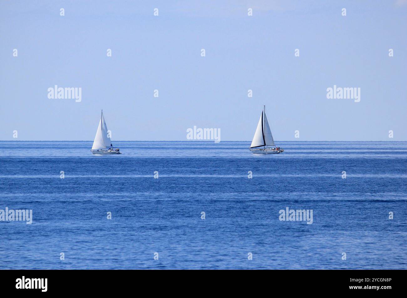 Two sailboats on open sea horizon Stock Photo - Alamy