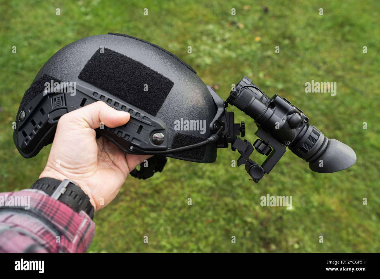 Tactical black helmet with night vision device in a man's hand, close ...