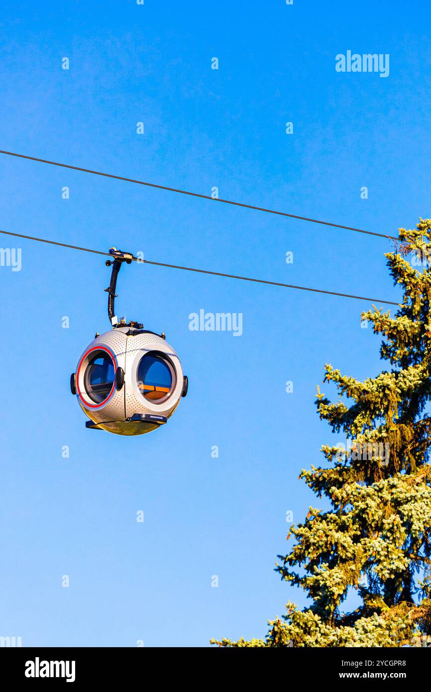 a cable car with round passenger cabins. cable car against blue sky ...