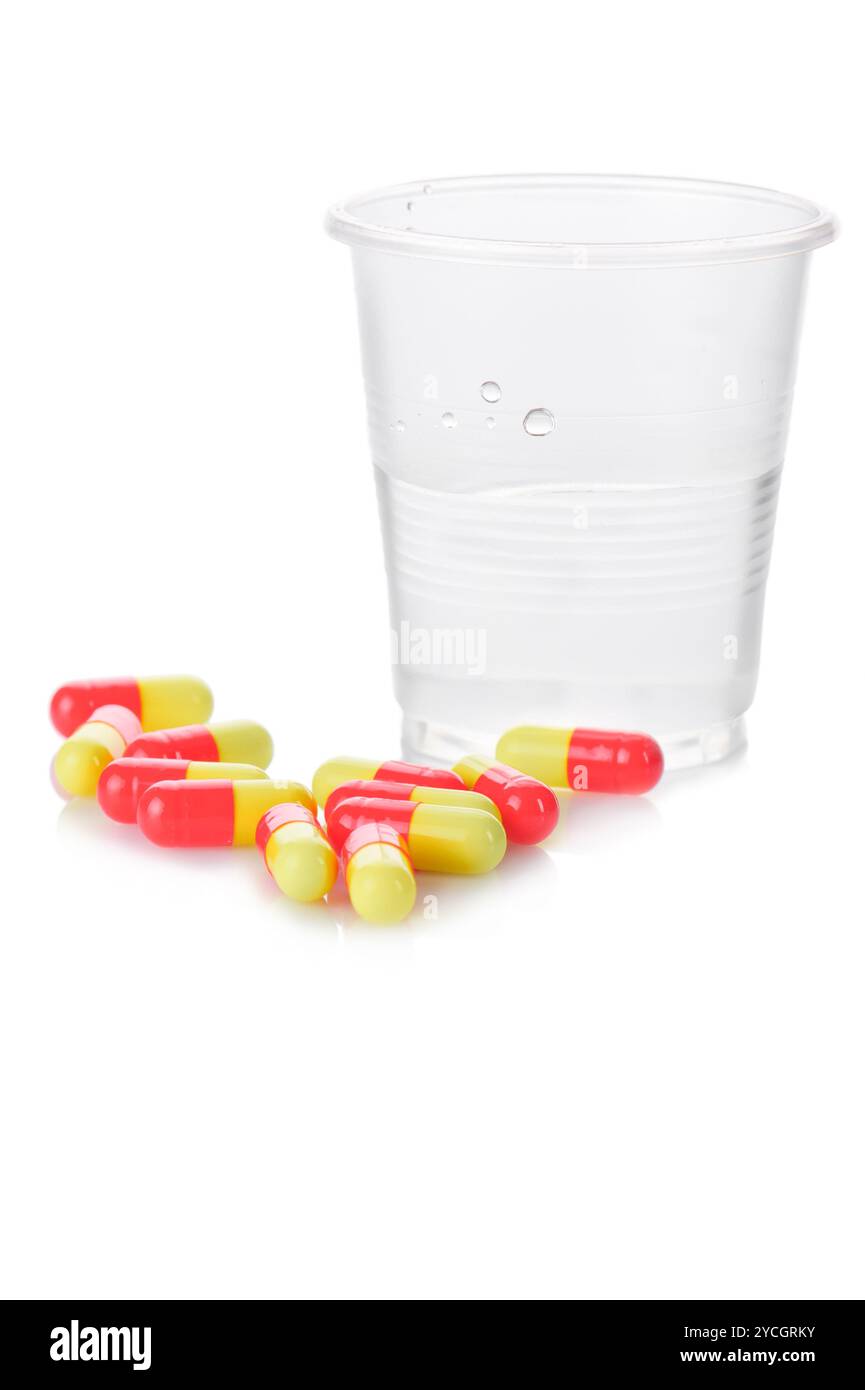 Pharmacy. Antibiotic pills and plastic glass of water on white ...