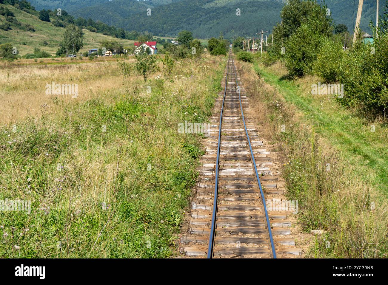Narrow gauge railway in a mountain village. Rails and sleepers. Railway ...