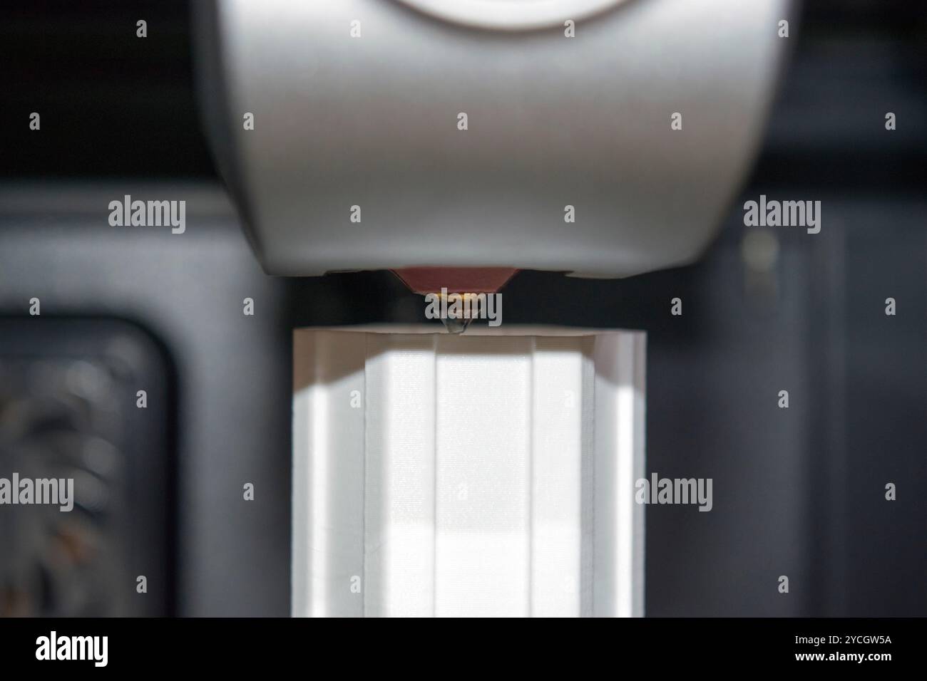 3d printing machine making a three dimensional white object from a digital file. 3D printer is ...