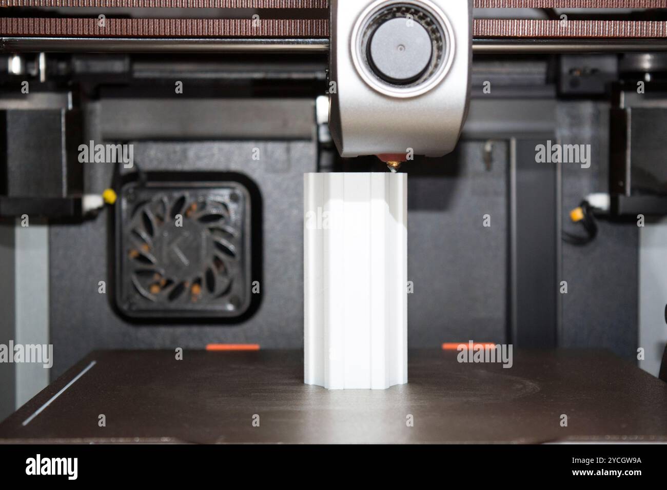 3d printing machine making a three dimensional white object from a ...